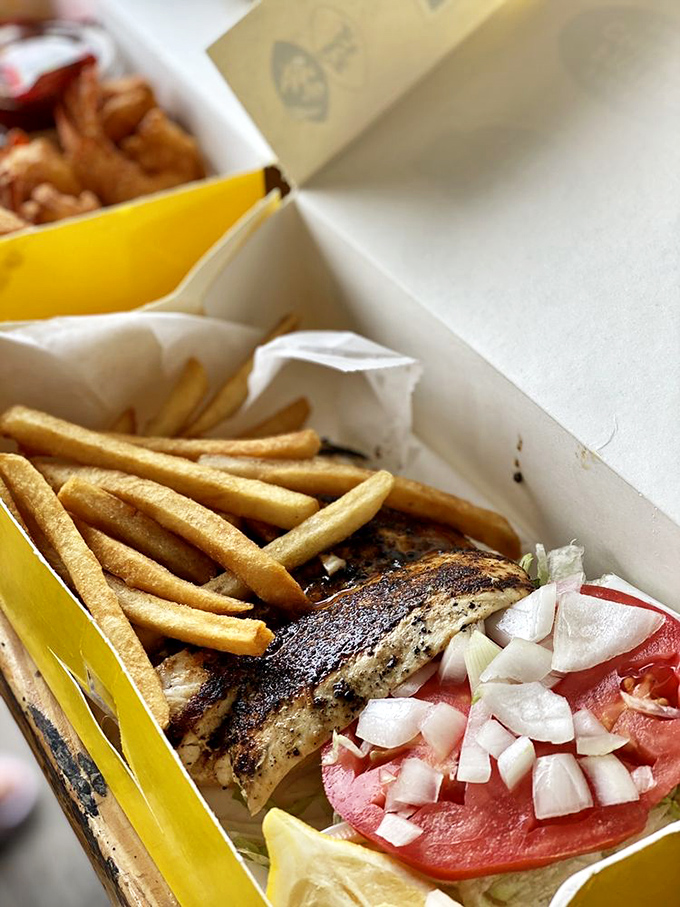 Blackened perfection meets golden fries in this paper boat of happiness. The tomato and onion aren't garnish—they're essential supporting actors.