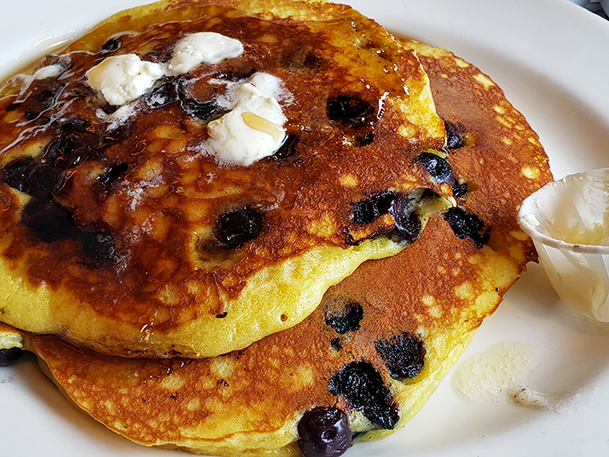 Blueberry pancakes that look like they're auditioning for a breakfast cereal commercial—fluffy, golden, and studded with berries that burst with every bite.