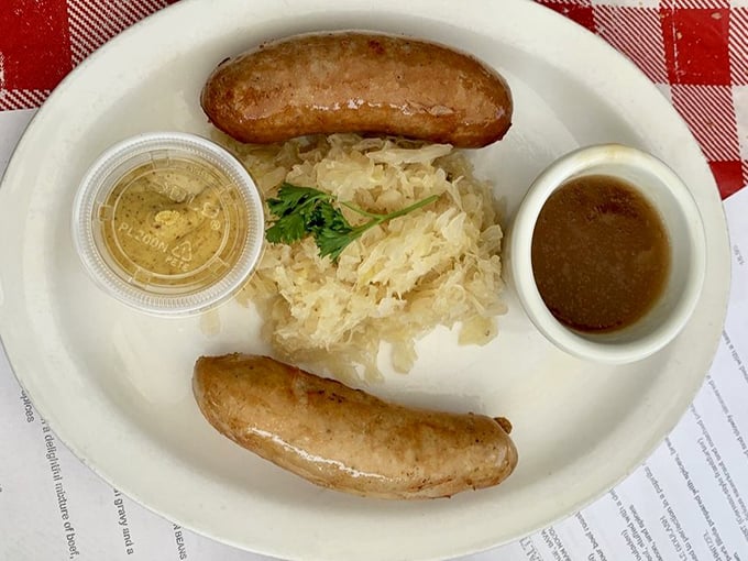 Bratwurst perfection: plump sausages nestled beside tangy sauerkraut. This isn't just lunch—it's a centuries-old German tradition served on a plate that demands respect.