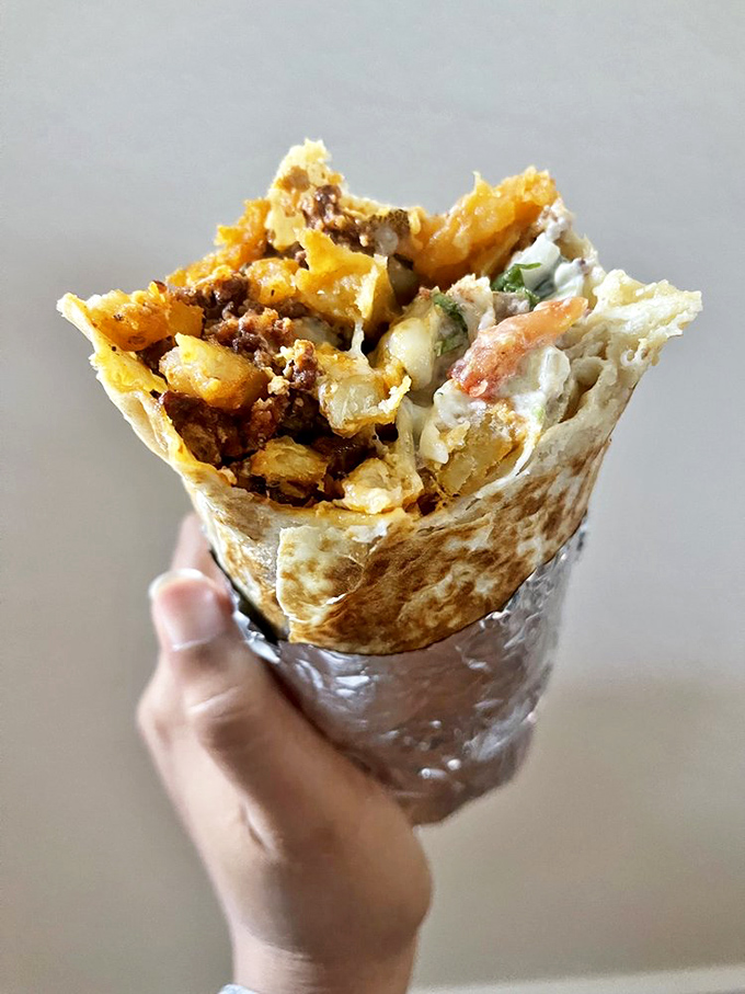 Behold the breakfast burrito in its natural habitat—halfway to your mouth! The cross-section reveals the perfect ratio of eggs, potatoes, and chorizo in tortilla harmony.