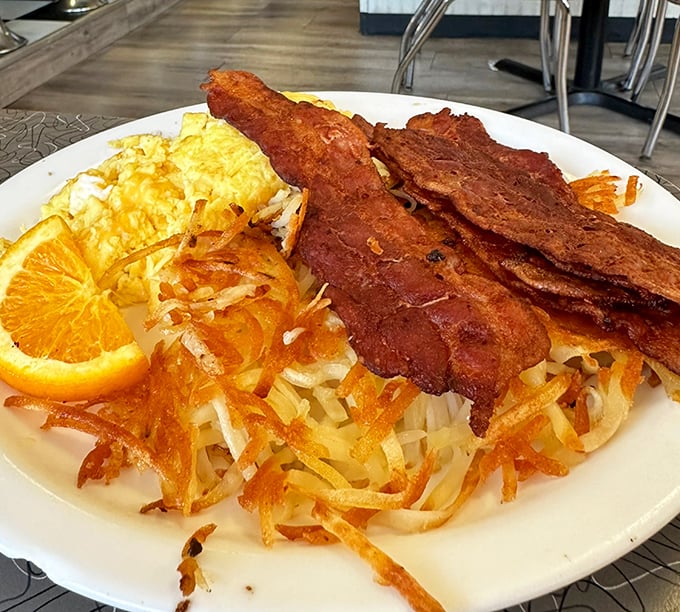 Breakfast perfection isn't complicated – just perfectly crispy hash browns, eggs with sunset-yellow yolks, and bacon that could make a vegetarian question their life choices.