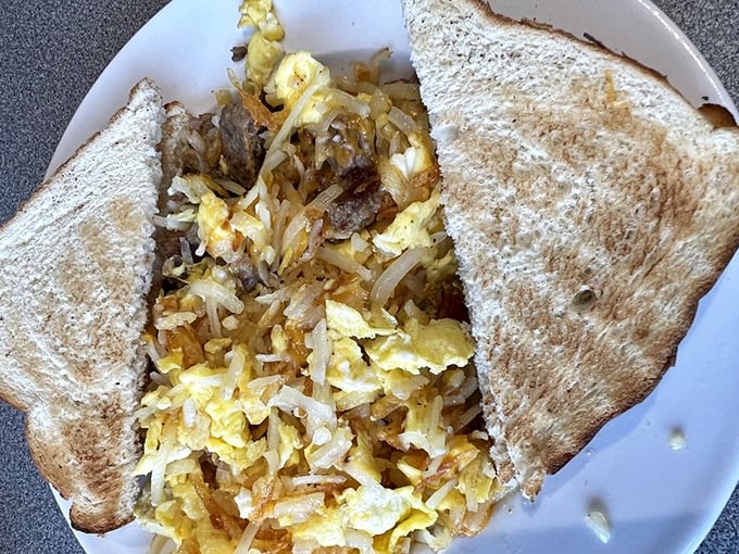 Breakfast hash that means business—eggs, potatoes, and meat dancing together in perfect morning harmony on toasted bread.