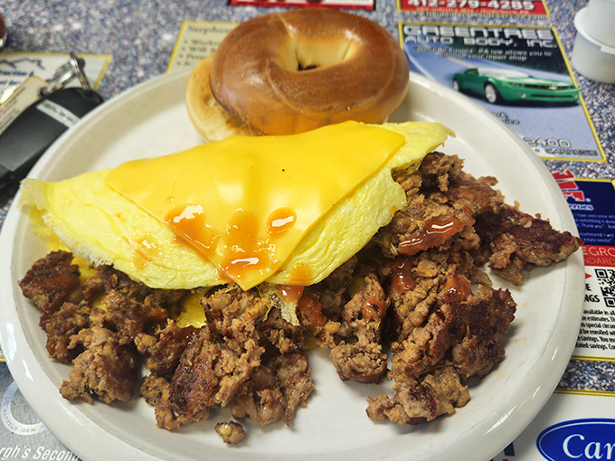 When breakfast demands more than cereal, this hearty plate answers the call – perfectly folded eggs, savory sausage, and a bagel that means business.