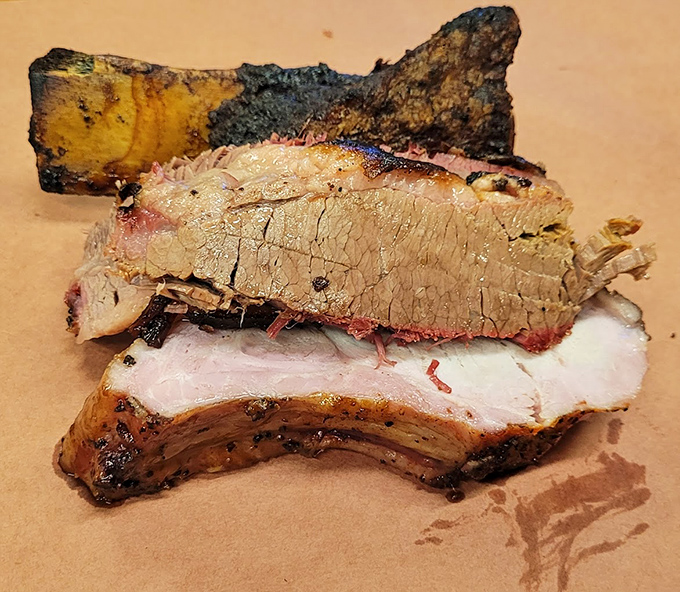 Behold the holy trinity of Texas barbecue—brisket with that telltale smoke ring, a hint of rib, and a bark so perfect it deserves its own art exhibition.