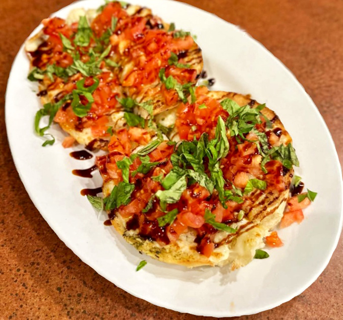 The bruschetta arrives like edible artwork—vibrant tomatoes, fresh herbs, and a balsamic drizzle that makes you wonder why you ever settled for lesser versions.