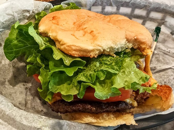 Behold the burger in its natural habitat—simple, unpretentious, and perfectly executed. That fresh lettuce and tomato aren't just garnish; they're the supporting actors that make the beef patty star shine brighter.