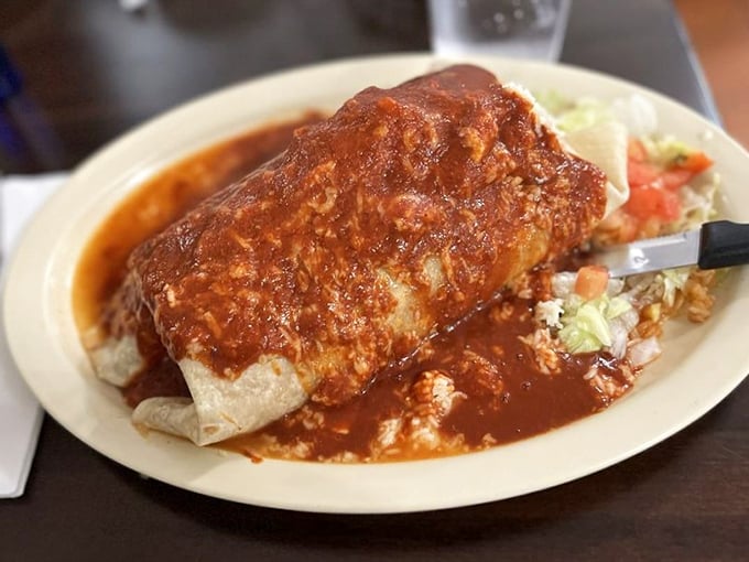 Not all heroes wear capes—some come wrapped in flour tortillas. This sauce-drenched burrito requires both hands, a stack of napkins, and absolutely zero shame.