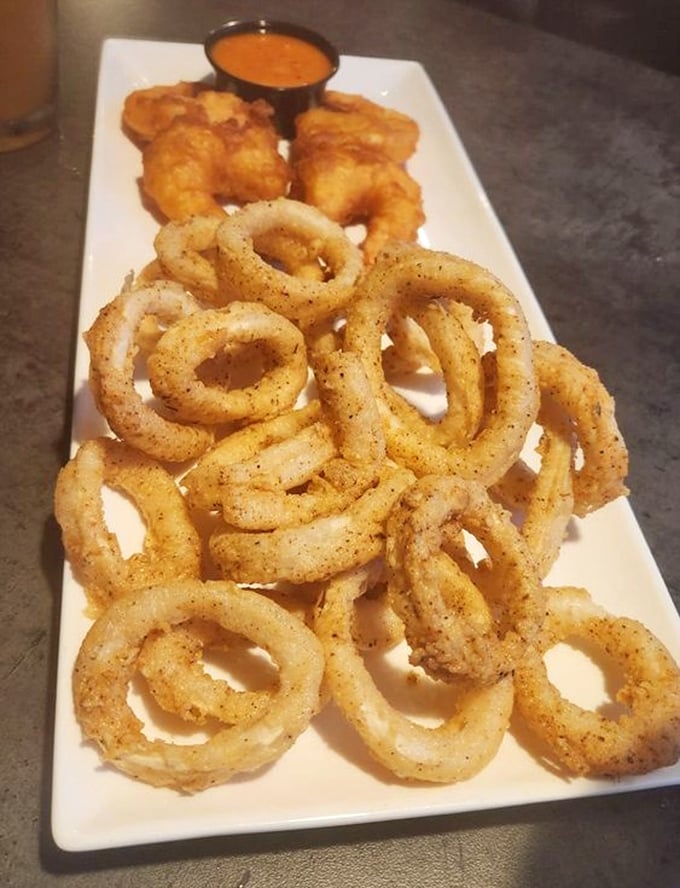 Crispy, golden calamari rings that snap like nature's perfect potato chip, paired with a dipping sauce worth bottling and taking home.