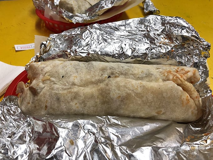 The foil-wrapped treasure reveals itself – a perfectly constructed burrito torpedo ready to launch your taste buds into orbit.