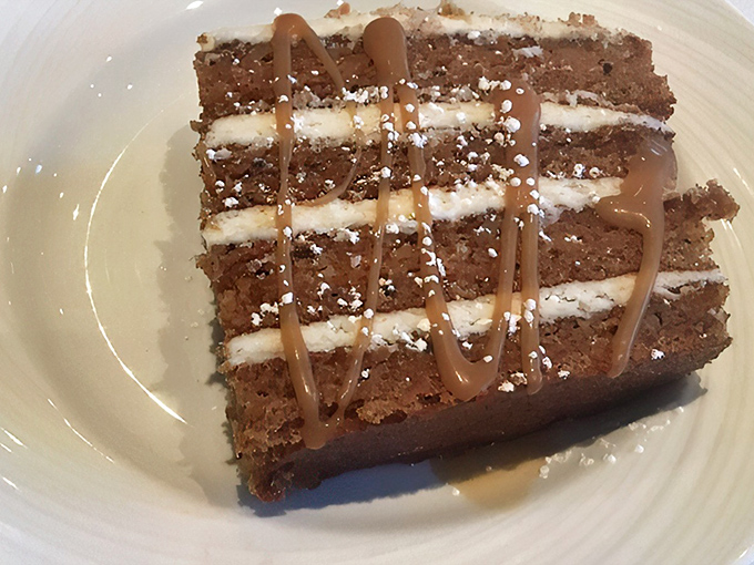 Layers of moist carrot cake with cream cheese frosting and caramel drizzle—proof that vegetables can absolutely count as dessert.