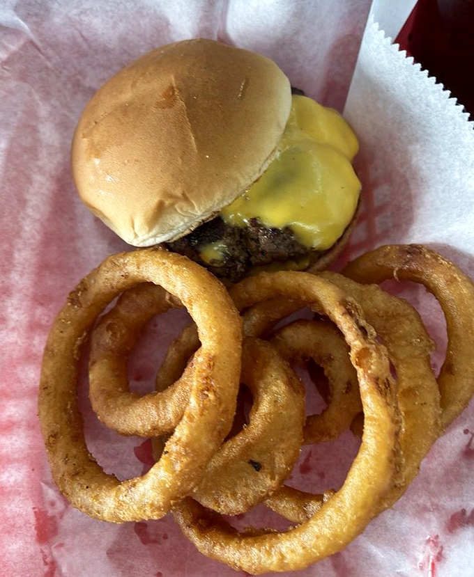 The humble cheeseburger, elevated to art form. Those onion rings aren't just sides—they're golden halos of crispy perfection.
