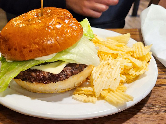 A proper diner burger doesn't need fancy aioli or artisanal buns—just honest beef, fresh toppings, and those perfectly ridged potato chips standing at attention.