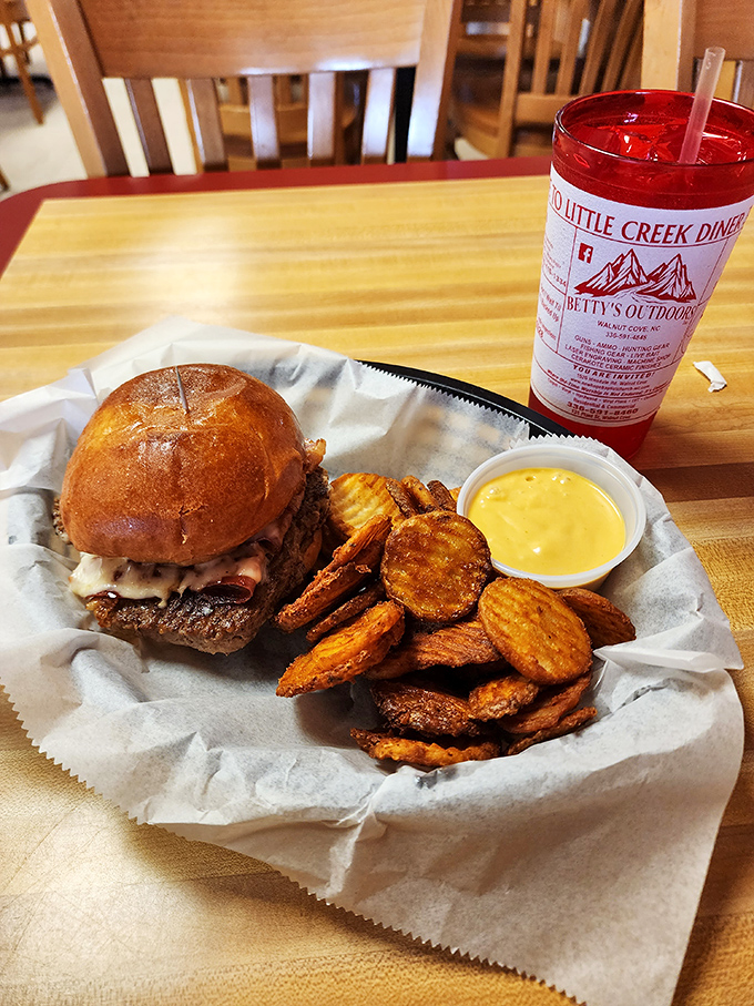 This isn't just a burger—it's edible architecture. A golden-brown bun cradling a hand-formed patty with melty cheese and those house-made chips? Pure comfort engineering.