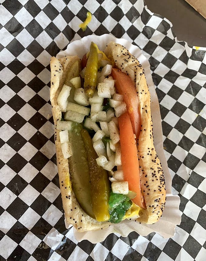 The Chicago dog in its natural habitat – poppy seed bun, vibrant toppings, and the cardinal rule: absolutely no ketchup allowed.