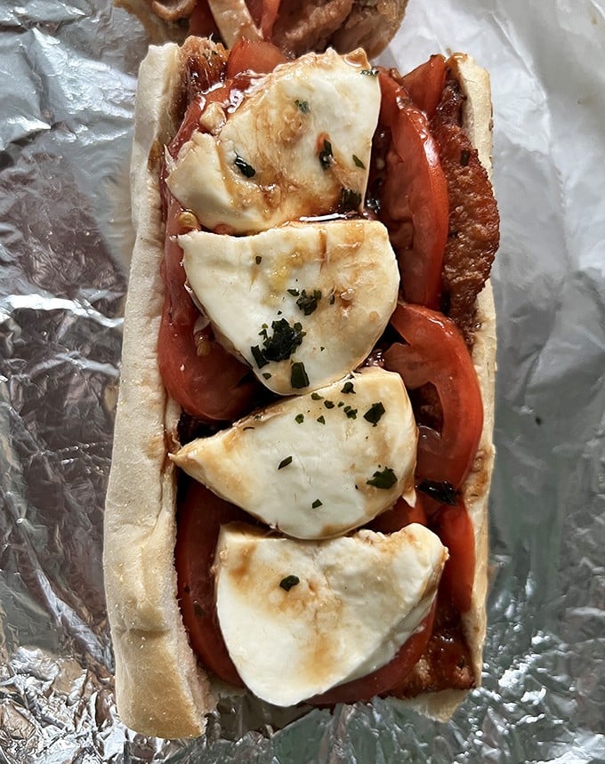 Fresh mozzarella, ripe tomatoes, and what appears to be prosciutto—the Italian heritage of South Philly captured between two pieces of bread.
