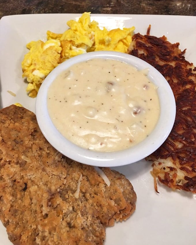 A breakfast symphony on a plate—country gravy, crispy hash browns, fluffy eggs, and a biscuit that deserves its own fan club.