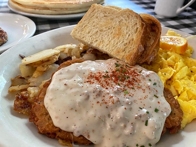 Comfort food architecture at its finest—a foundation of crispy chicken, crowned with creamy gravy and sprinkled with just enough spice.