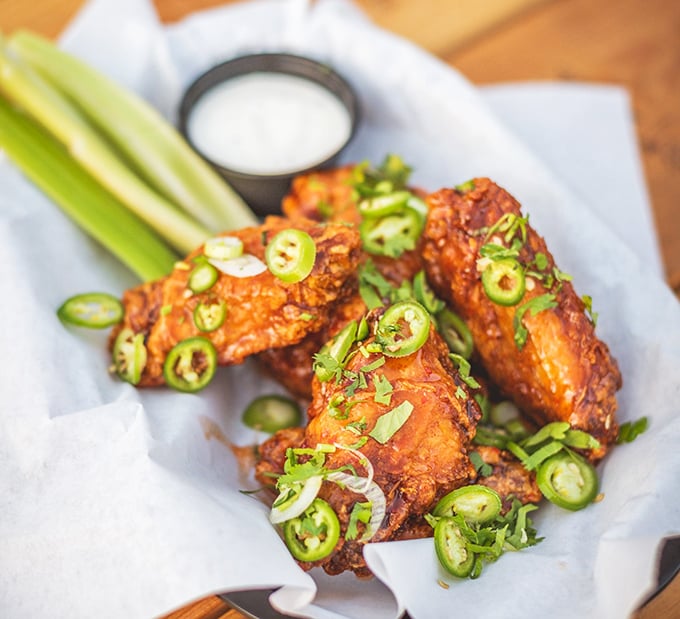 These aren't just wings; they're flavor delivery vehicles garnished with jalapeños for those who believe heat is not just a temperature but a lifestyle choice.