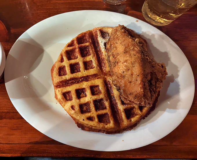 The chicken and waffle alliance continues its delicious diplomacy here—crispy, golden-brown chicken making peace with a fluffy, butter-kissed waffle on neutral territory.