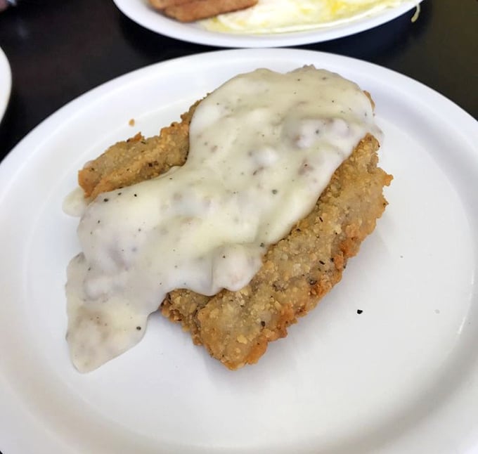 This chicken fried steak swimming in creamy gravy isn't just breakfast—it's therapy on a plate, offering comfort that no therapist's couch could match.
