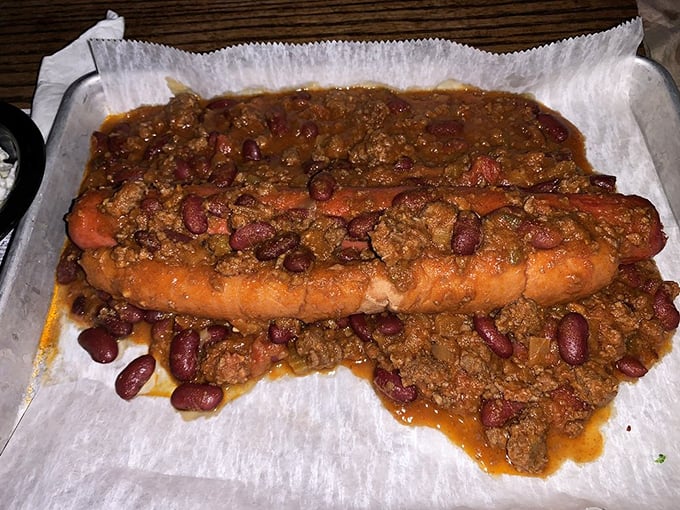Not your average chili dog. This beast comes buried under a mountain of hearty beef chili and beans—fork required, napkins essential.