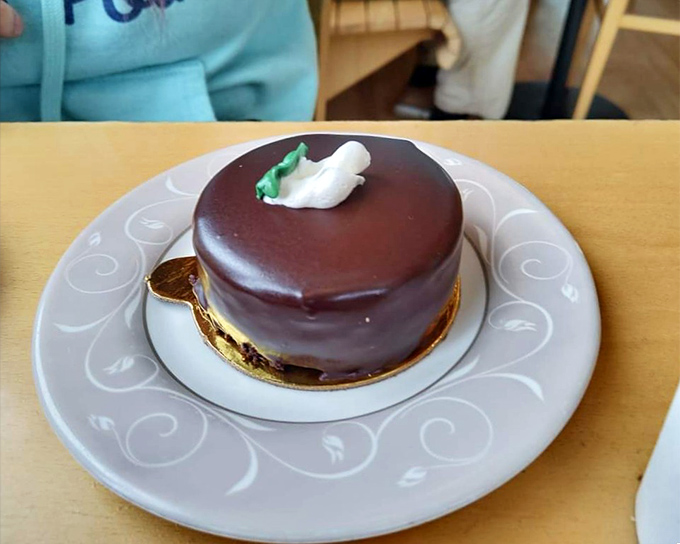 This chocolate mousse cake sits like edible architecture, defying both gravity and your willpower with equal success.