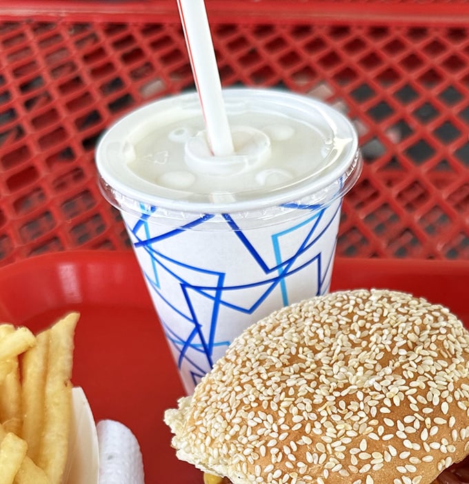 A proper milkshake served with fries and a burger—the holy trinity of American drive-in cuisine that makes dietitians weep and souls sing.