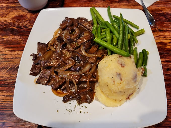 The legendary chopped steak—tender beef smothered in savory gravy and caramelized onions—proves that simple food done right is culinary poetry.