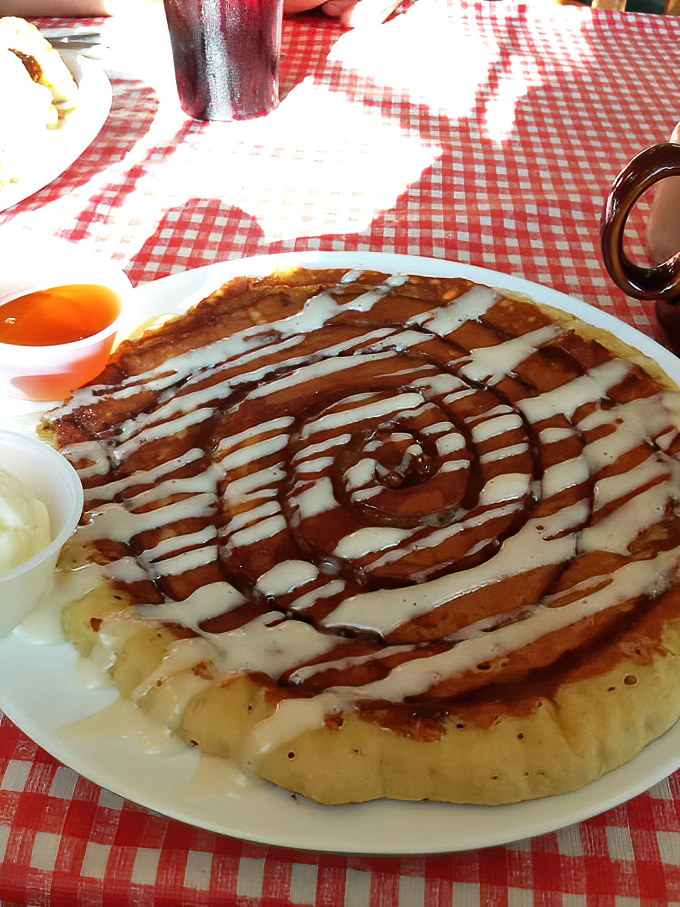 Behold the cinnamon roll pancake—where breakfast and dessert collide in a spiral of morning glory that makes Monday feel like Saturday.
