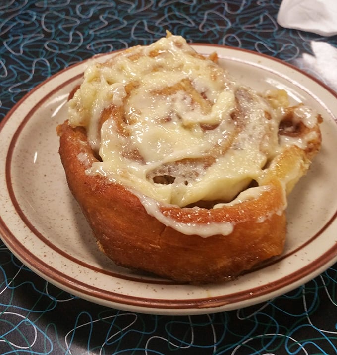 This cinnamon roll isn't just breakfast—it's dessert masquerading as a morning meal, with melty icing cascading down spirals of cinnamon-sugar perfection.