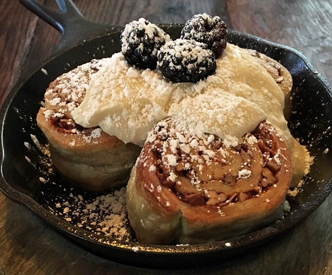 Cinnamon rolls that deserve their own ZIP code – pillowy spirals crowned with vanilla cream cheese frosting and a scattering of nuts for textural perfection.