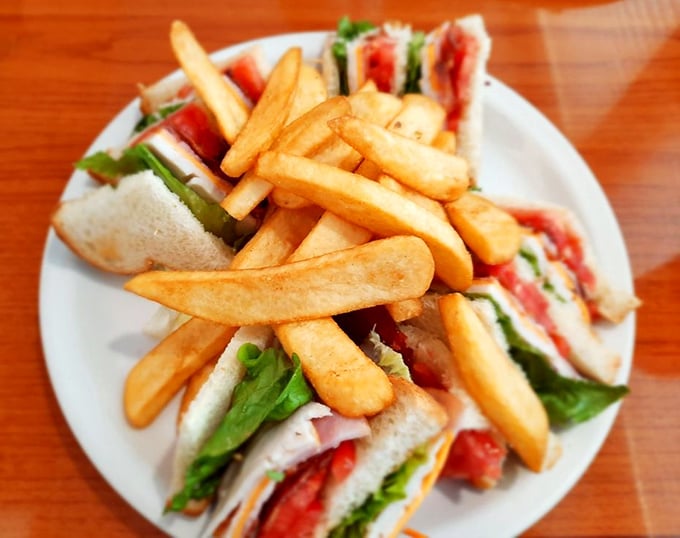 This club sandwich isn't playing around—layers stacked higher than Atlanta rent prices, with golden fries standing guard.