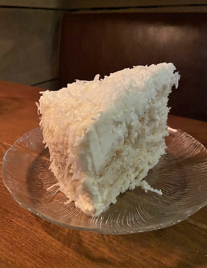 Behold the legendary coconut cake—a towering achievement of fluff, cream, and coconut that makes grown adults contemplate licking the plate.