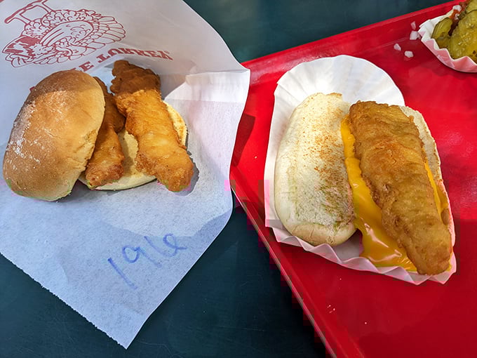 The Fish Dog sandwich arrives like an old friend you didn't know you missed—golden, crispy cod nestled in a soft bun with melted cheese that whispers, "Where have I been all your life?"