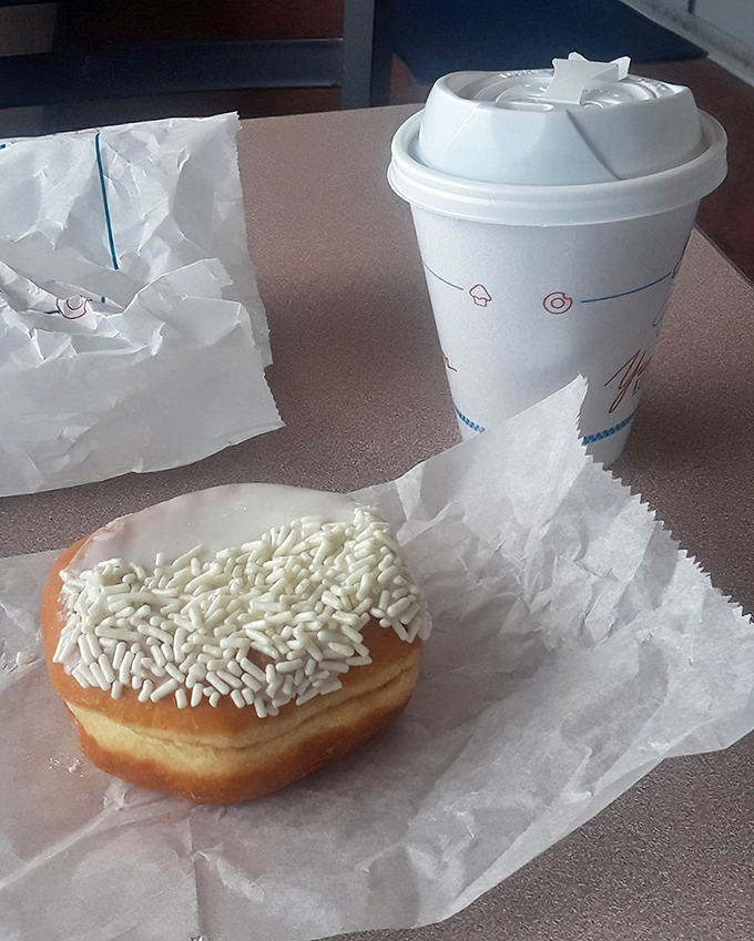The universal language of happiness: a fresh donut with white sprinkles alongside coffee in a no-nonsense cup. Some traditions need no improvement.
