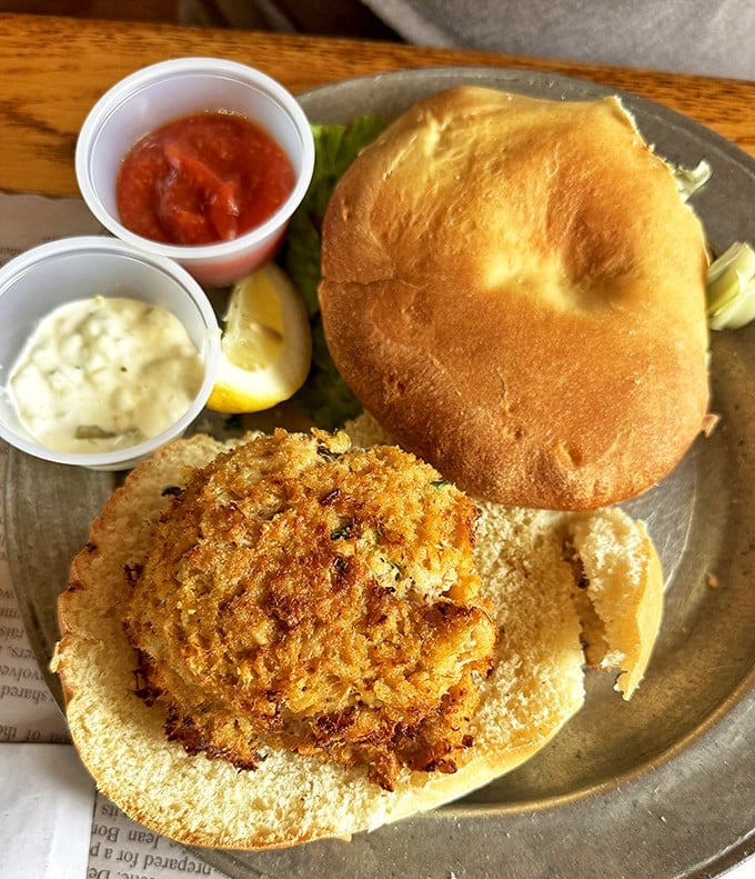 This isn't just a crab cake sandwich—it's a golden-crusted masterpiece of jumbo lump meat, served with classic accompaniments that let the seafood shine.