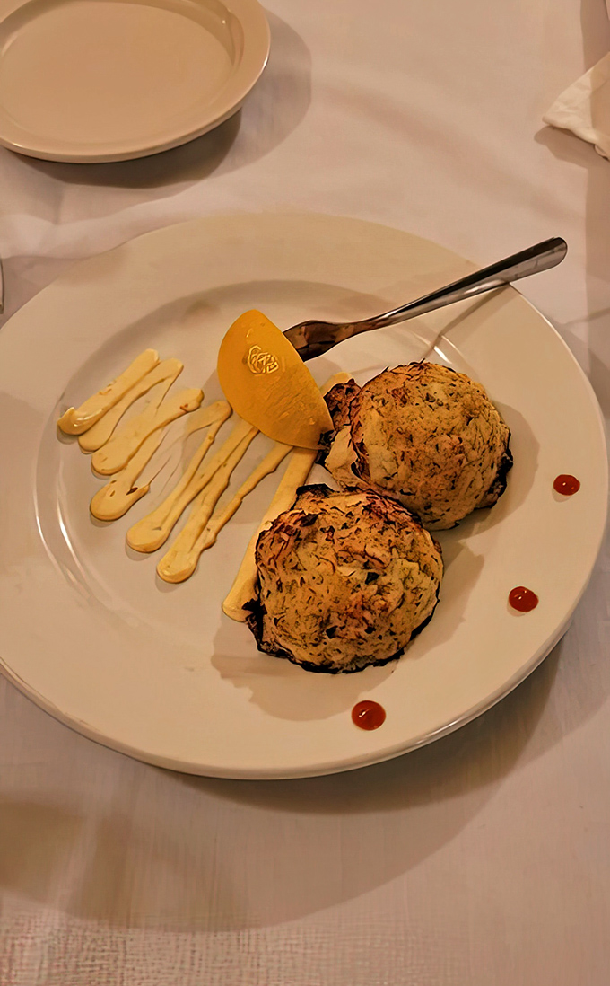Artfully plated crab cakes with decorative sauce flourishes – because in Wisconsin, even bar food deserves a touch of elegance.