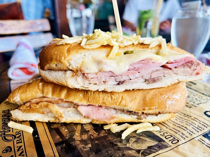 The legendary Cuban sandwich in its natural habitat – layers of pork, ham, and cheese pressed between bread that crackles with each heavenly bite.