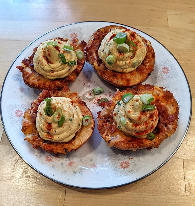 These aren't your average potato skins. Crispy vessels topped with creamy, spiced filling and fresh scallions—comfort food that got a graduate degree.