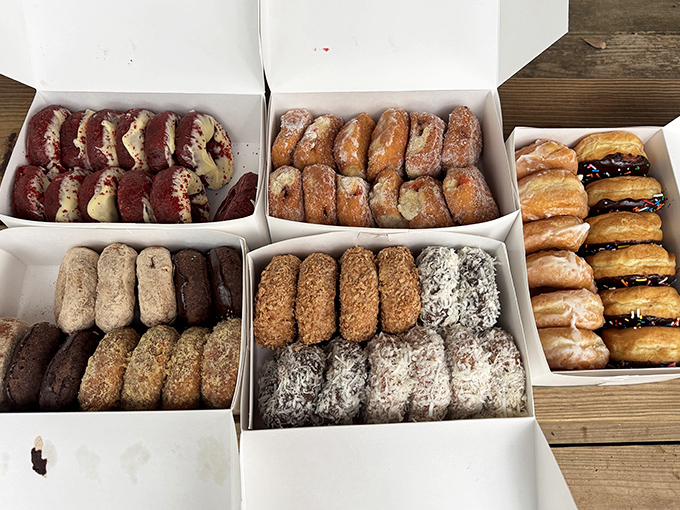 Donut boxes that deserve their own zip code. The red velvet and chocolate varieties are calling your name louder than the ocean waves.