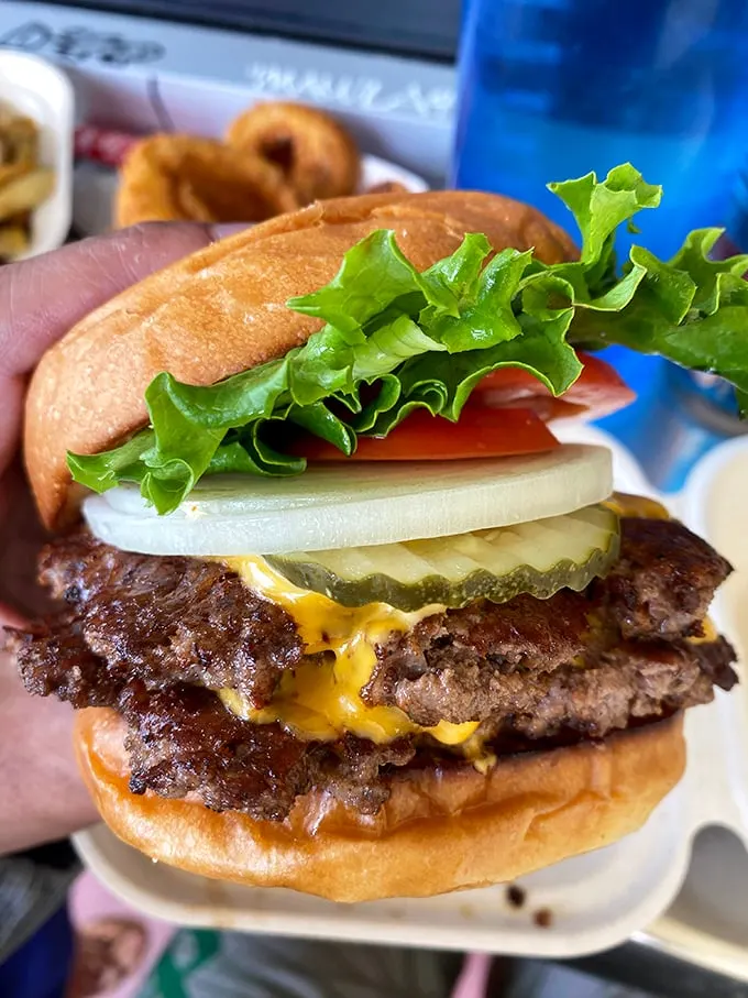 Behold the double cheeseburger in all its glory—juicy patties, melty cheese, and fresh veggies stacked between pillowy buns. Napkins required, regrets impossible.