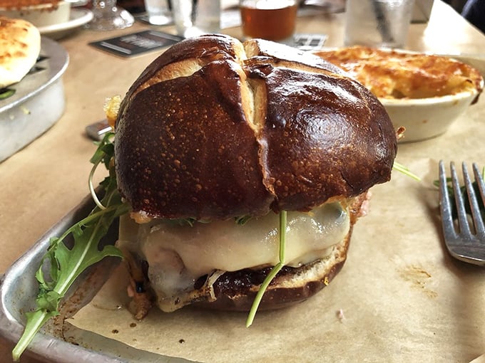 Not your average burger relationship—this one's built to last. A pretzel bun cradles melted cheese and arugula in a sandwich that demands both hands and your full attention.
