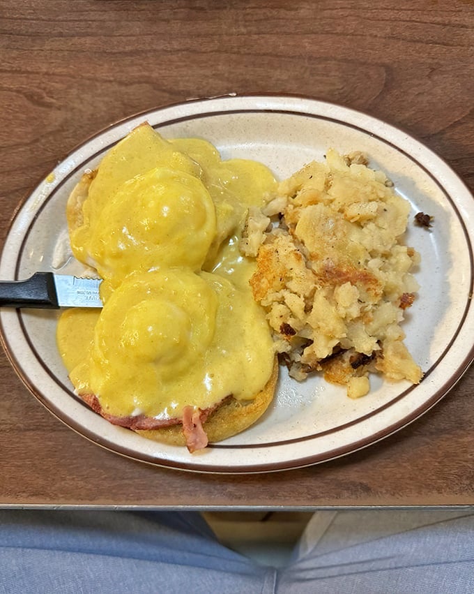 Eggs Benedict that would make the Pope jealous—perfectly poached eggs nestled on ham, draped in hollandaise, with hash browns that achieve the crispy-fluffy paradox.