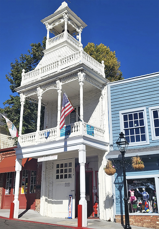 This ornate white firehouse looks like it belongs in a Wes Anderson film. The intricate Victorian detailing showcases the town's architectural pride and craftsmanship.