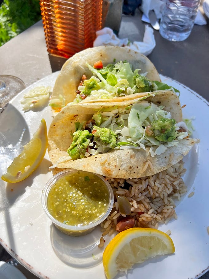 Fish tacos that make you question why you ever eat anything else. That green sauce isn't just condiment—it's liquid sunshine in a cup.