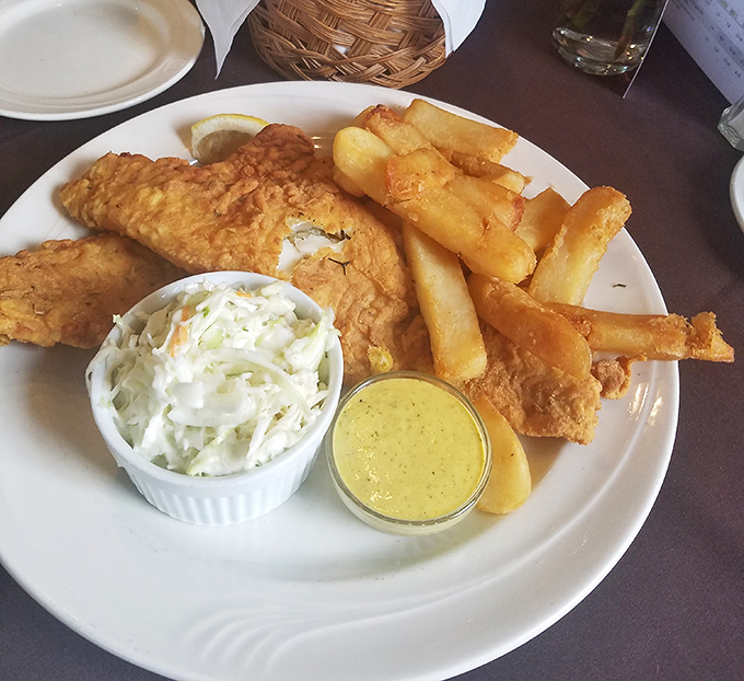 Golden-battered fish alongside crispy fries and house-made slaw – the kind of plate that makes you forget your table manners.