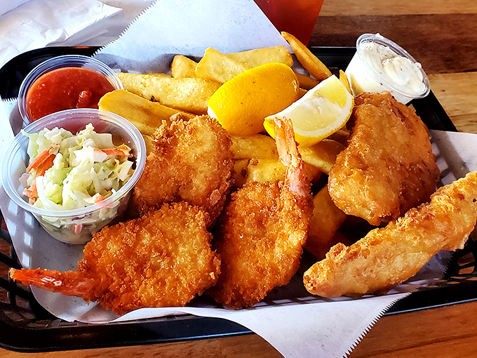 Golden-battered fish and chips sit alongside, coleslaw, and a wedge of lemon—a seafood platter worthy of making Neptune trade his trident for a fork.