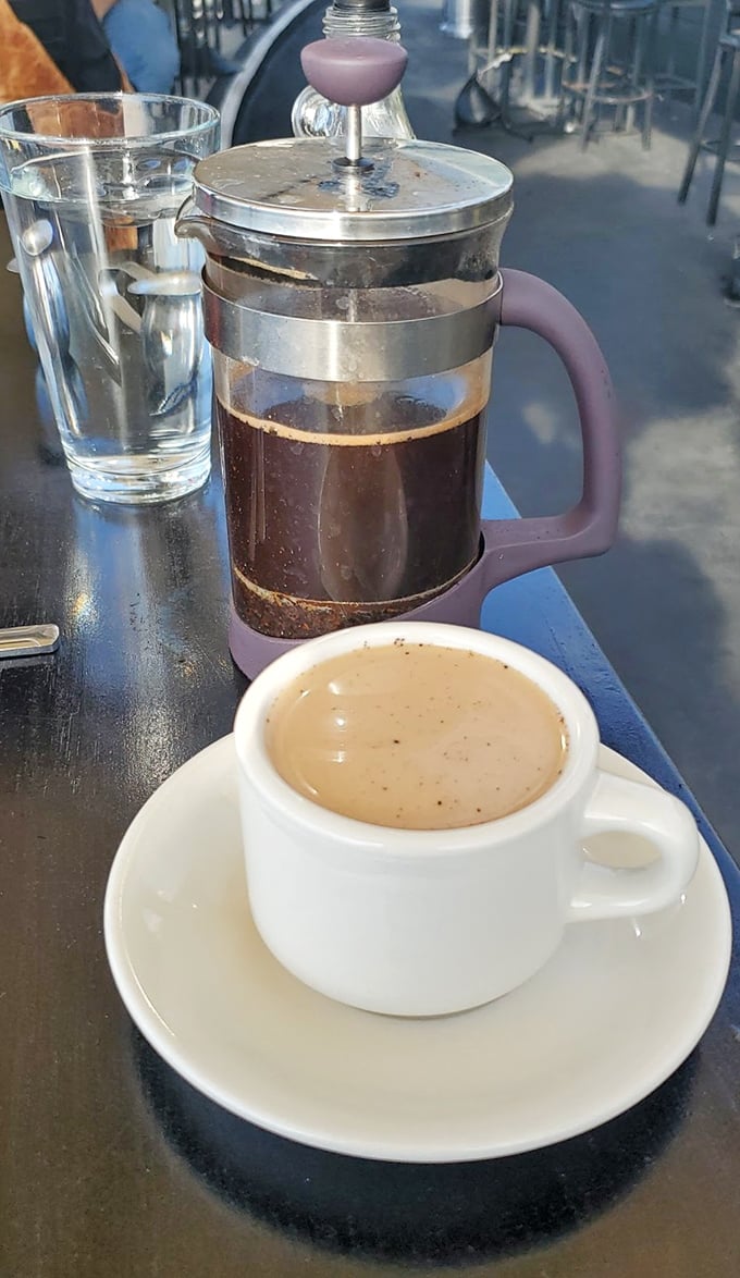 The French press coffee arrives like a dignified ambassador, diplomatically balancing the impending sugar rush that's about to follow.