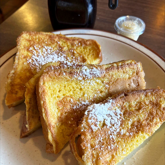 Golden-edged French toast dusted with powdered sugar—proof that simplicity, when done right, outshines even the fanciest brunch concoctions in town.