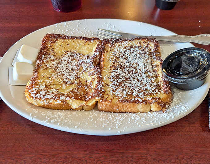French toast that puts ordinary bread to shame. Dusted with powdered sugar and waiting for its maple bath, this is breakfast as art form.